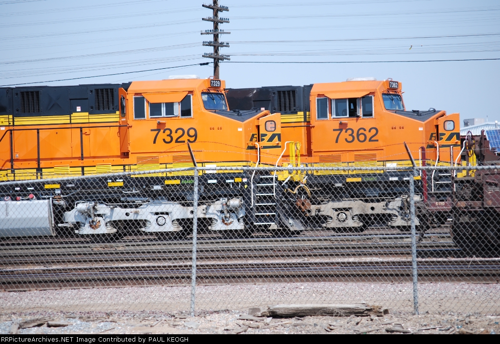 BNSF 7329 and BNSF 7362 both with their cab doors ajar sit on the siding at the BNSF Fresno yard
